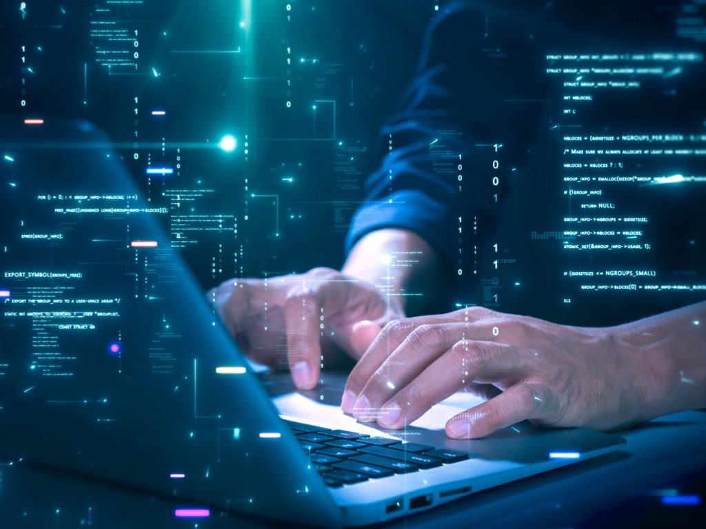 close-up-of-hands-typing-on-a-laptop-with-glowing-programming-code-and ...
